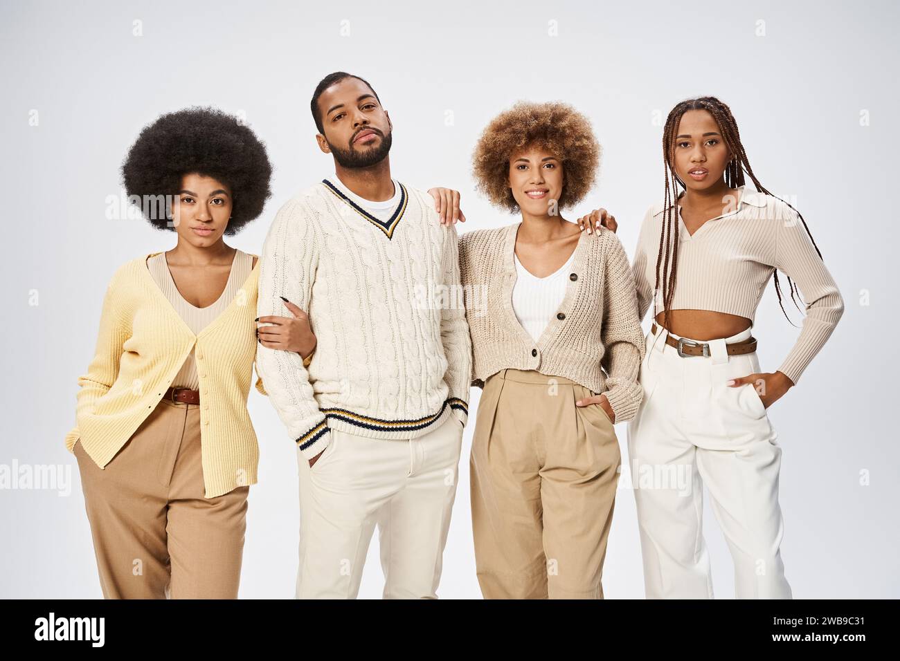 group of elegant african american friends standing together on grey ...