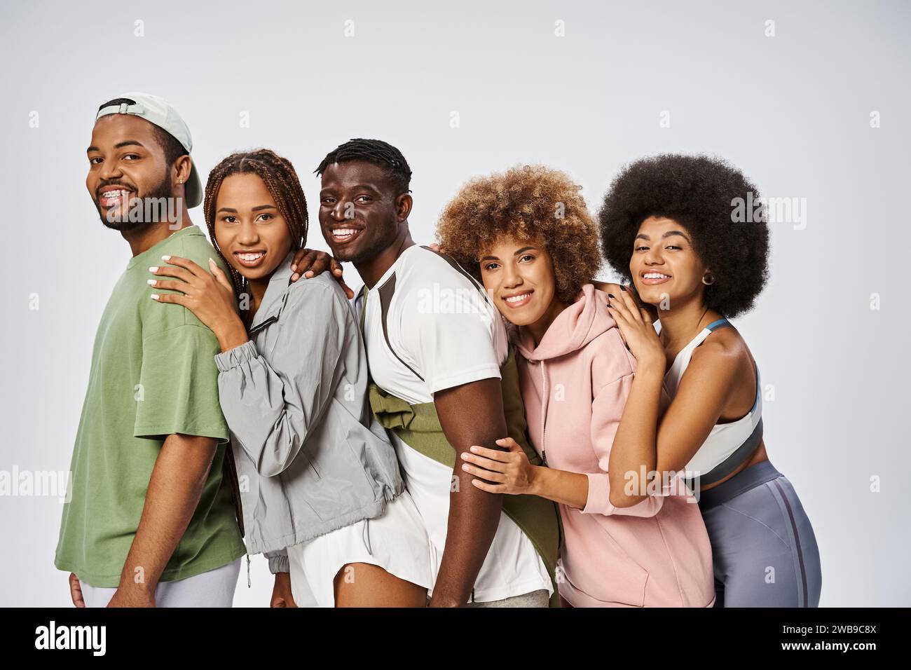group of positive young african american friends leaning on each other ...