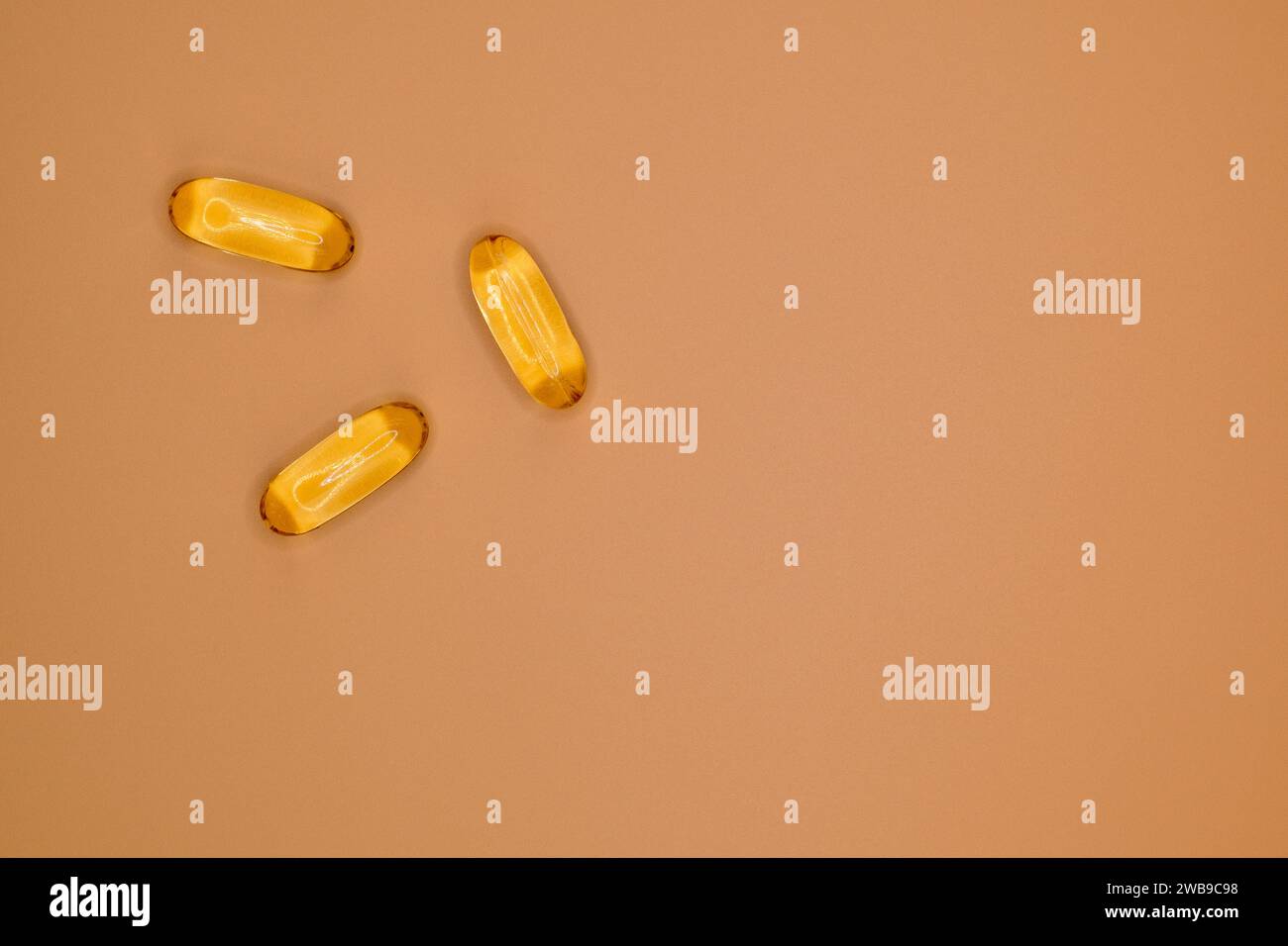 Omega 3 fish oil gel capsules on peach color background. Cod liver oil ...