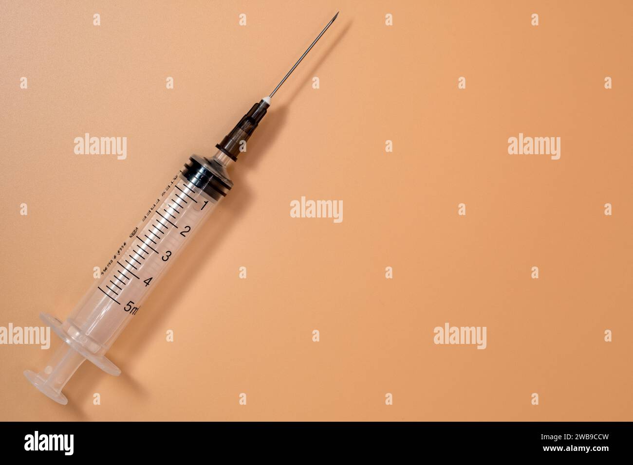 Empty 5ml syringe with needle on peach background. Copy Space Stock ...