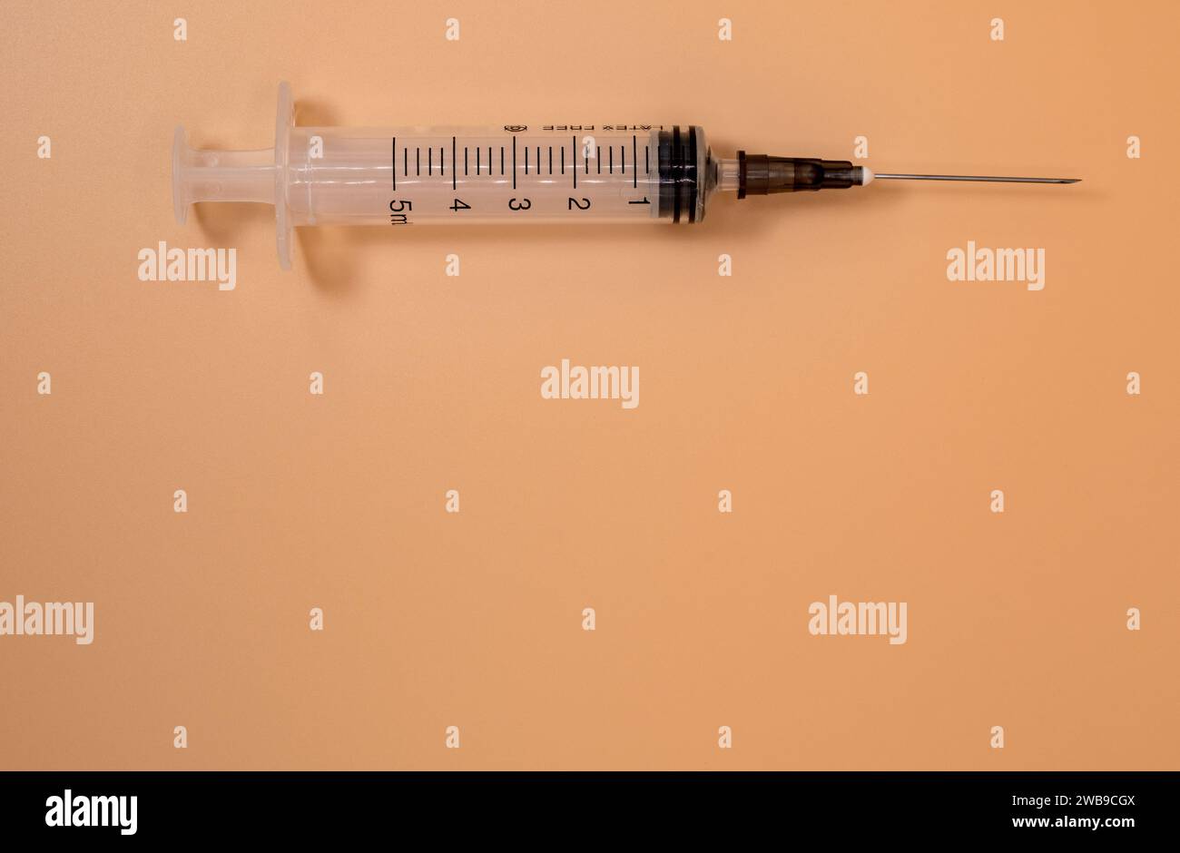 Empty 5ml syringe with needle on peach background. Copy Space Stock ...
