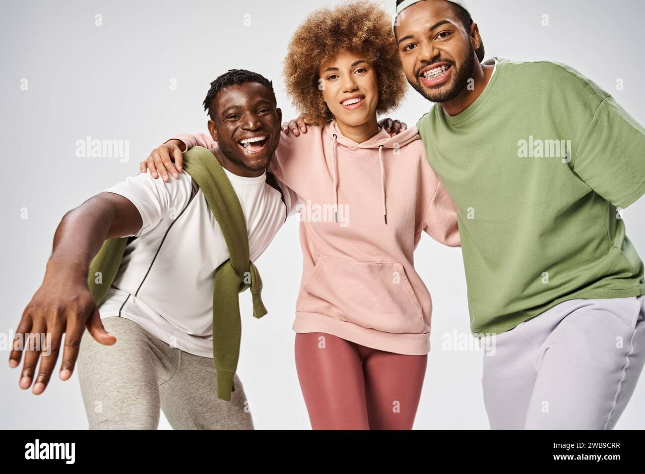 cheerful african american men and woman standing on grey background ...
