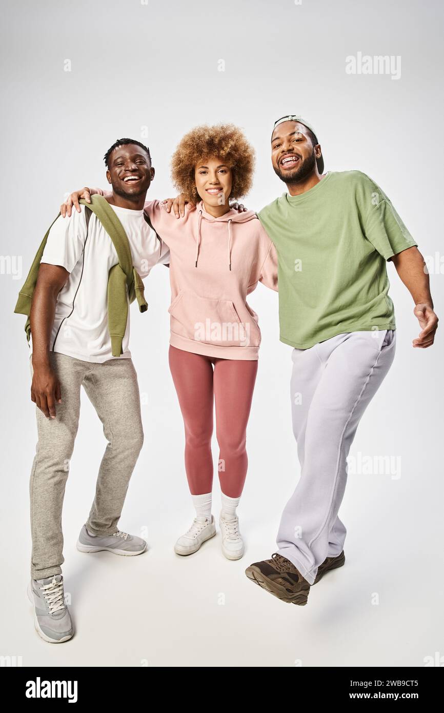 joyful young african american men and woman standing on grey background ...