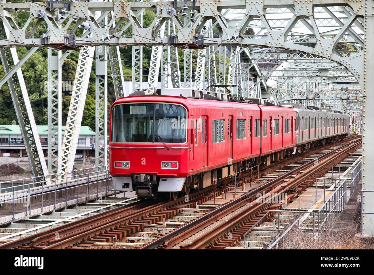 Commuter train crossing railway bridge in Inuyama, Japan. Local public ...