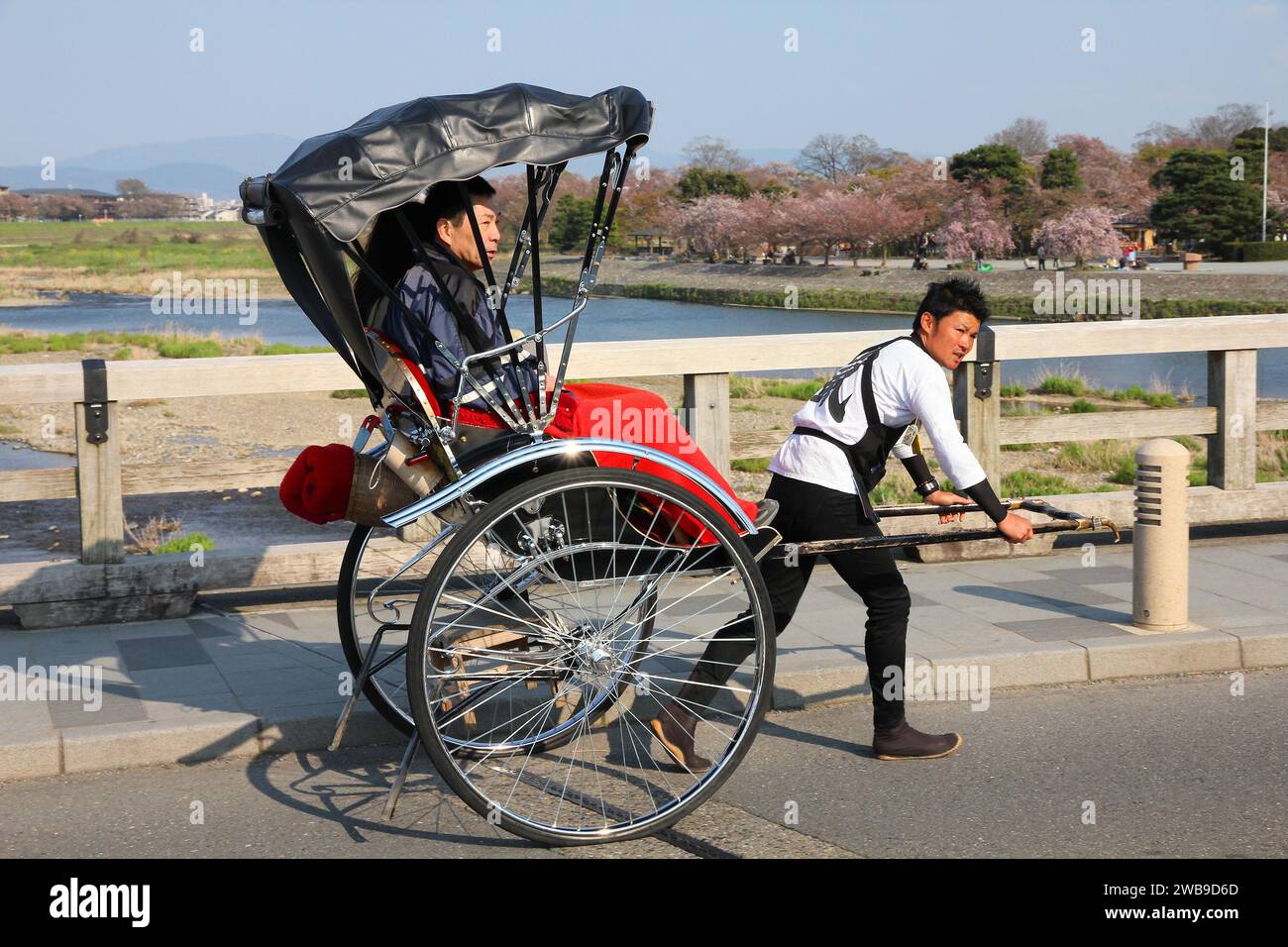 KYOTO, JAPAN - APRIL 17, 2012: Visitors ride a rickshaw in Arashiyama ...