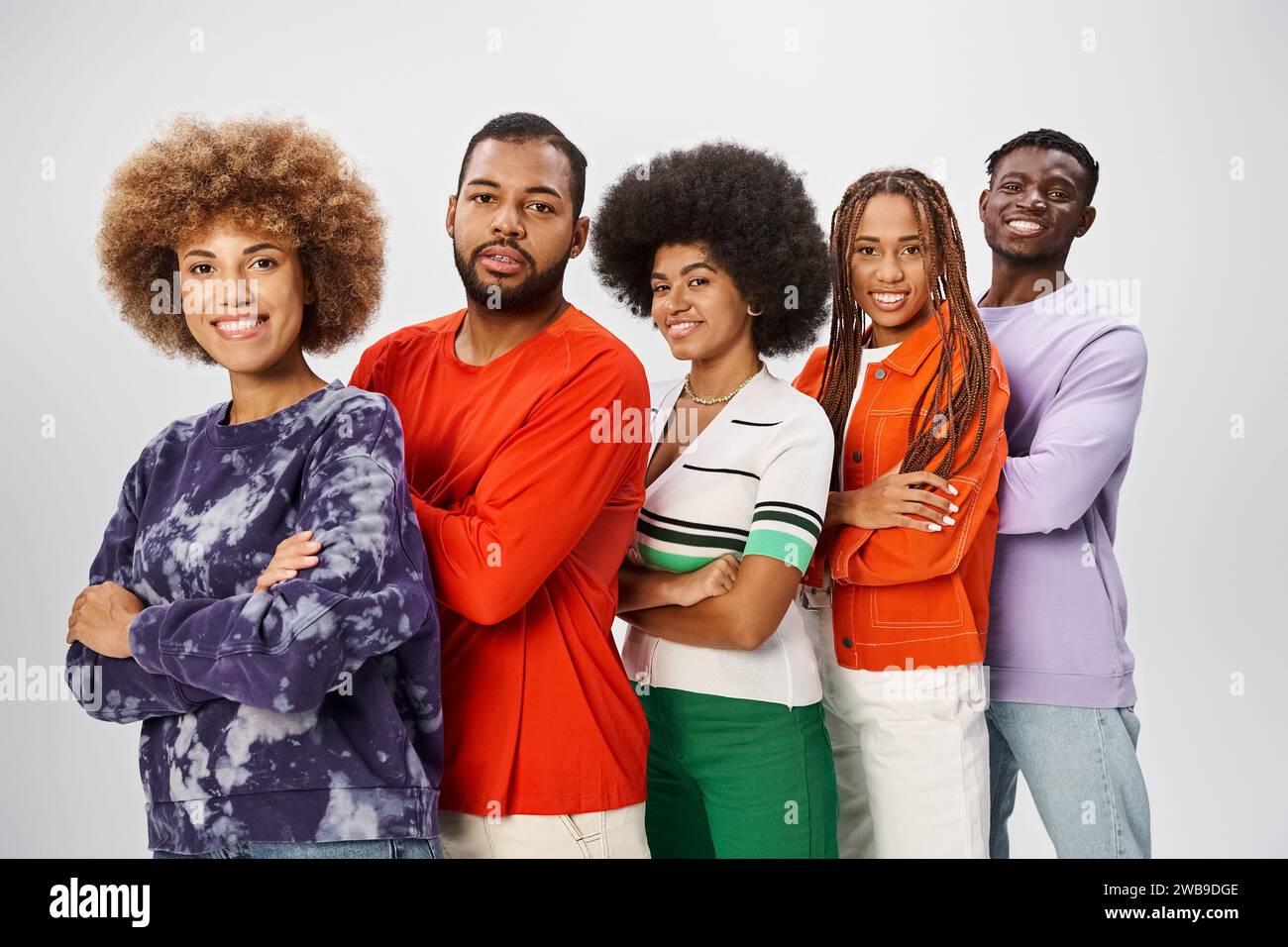 happy african american people in casual attire posing together on grey ...