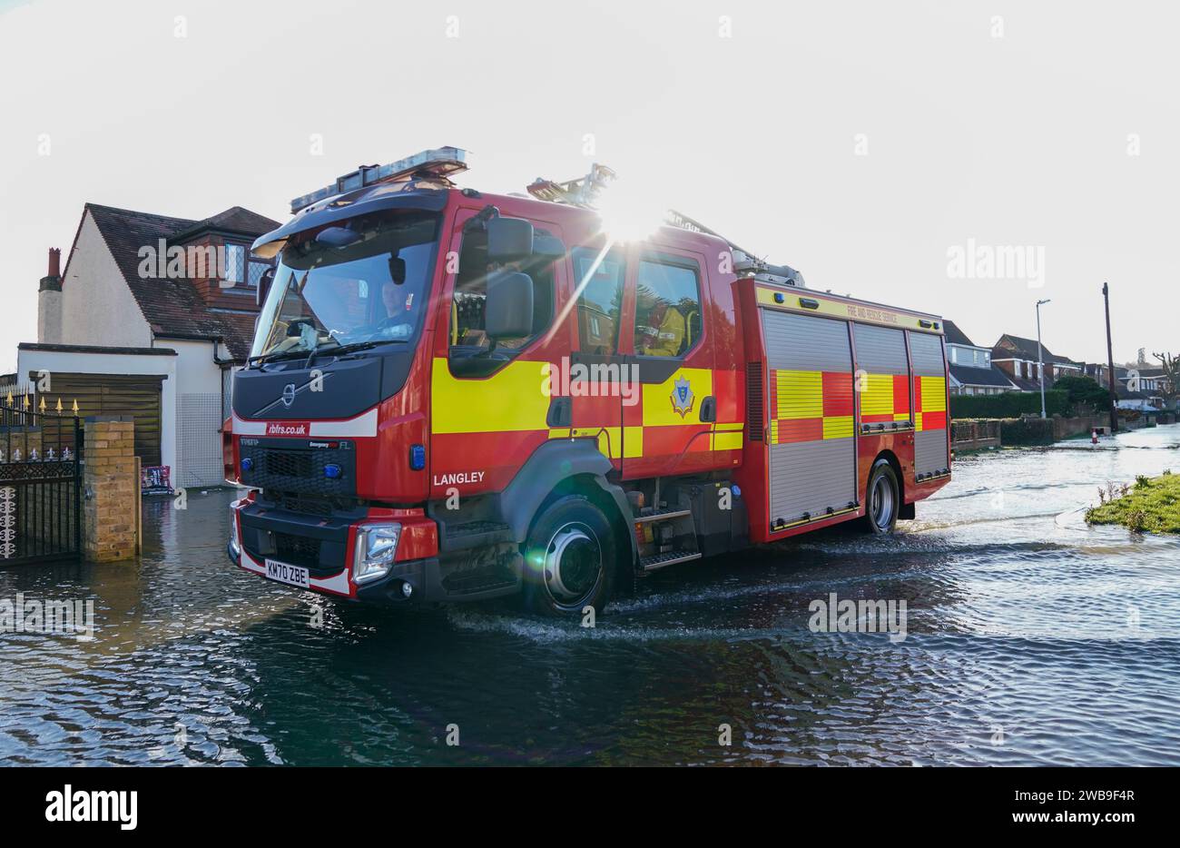 A fire engine is driven through flood water in Wraysbury, Berkshire ...