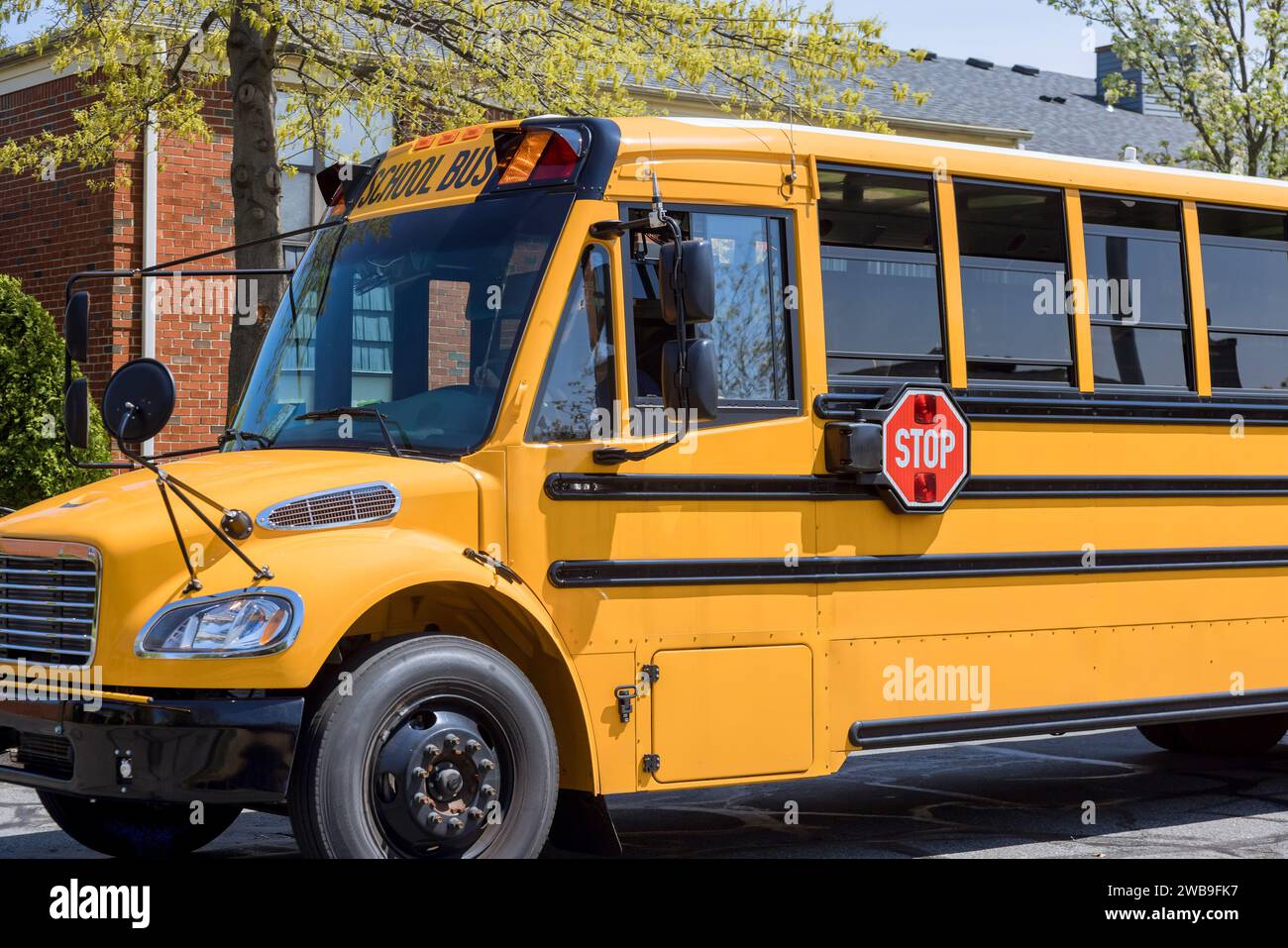 Yellow school bus driving along street at suburban sleep area Stock ...