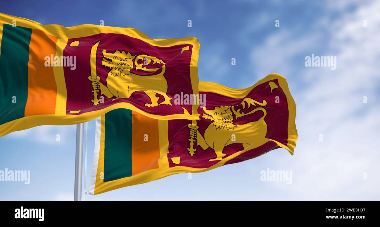 Two Sri Lanka national flags waving on a clear day. island country in ...