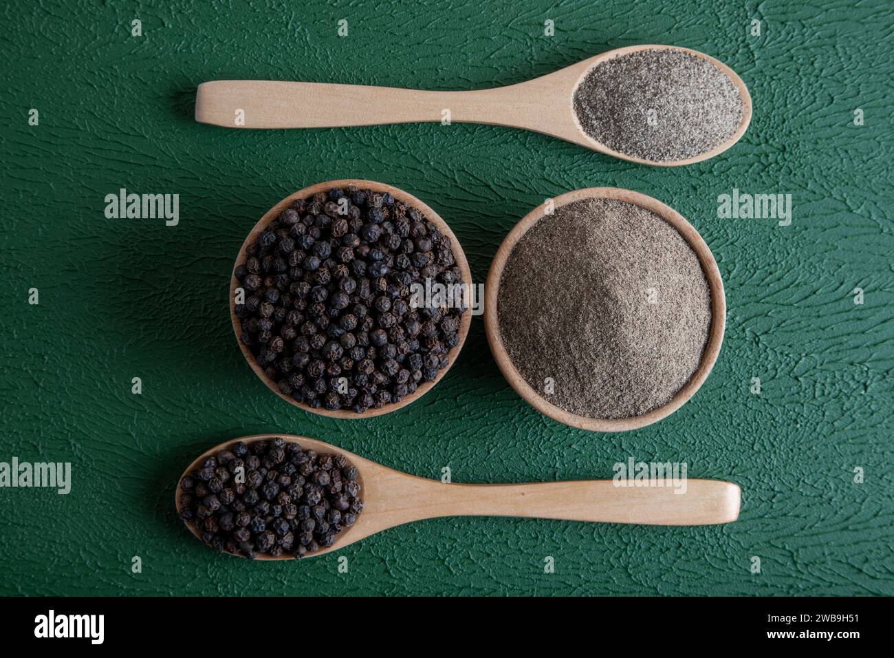 Ground black pepper green background with black pepper grains on top ...