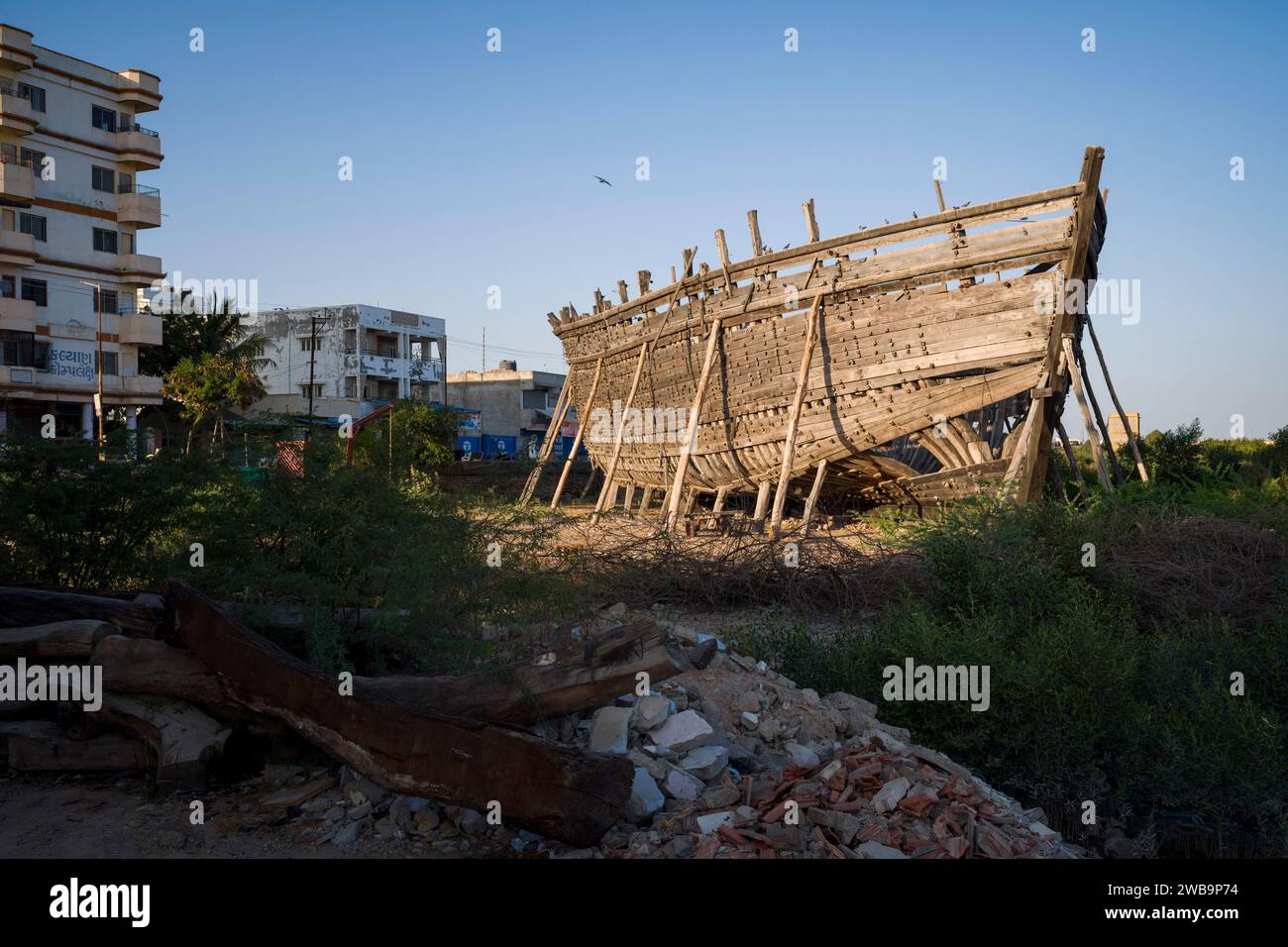 A traditional ship under construction sits across the road from high ...