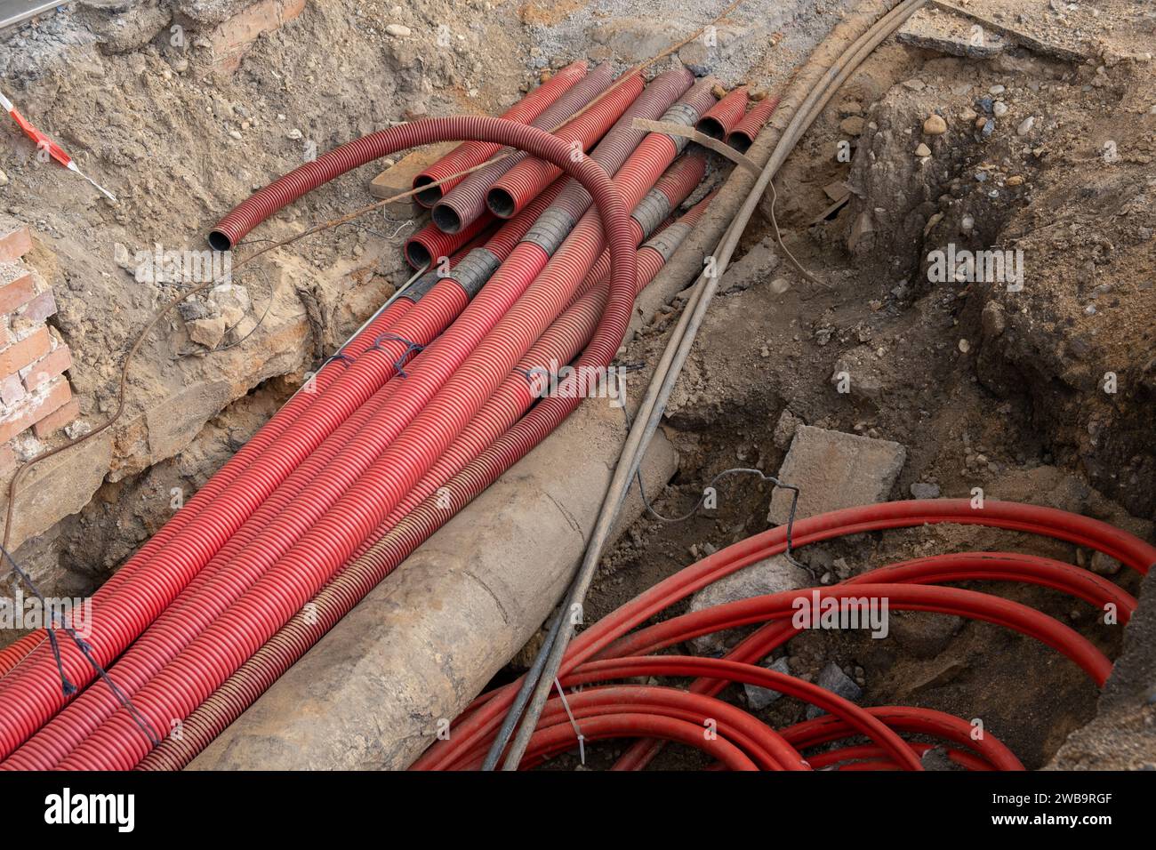 pipe and cables in red corrugated pipe are buried underground on the ...