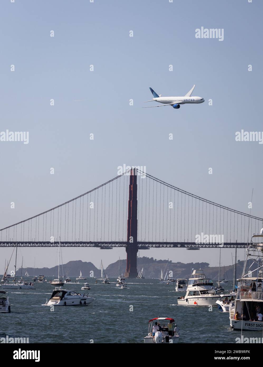 A United Airlines Boeing 777 jet flying over the Golden Gate Bridge in ...