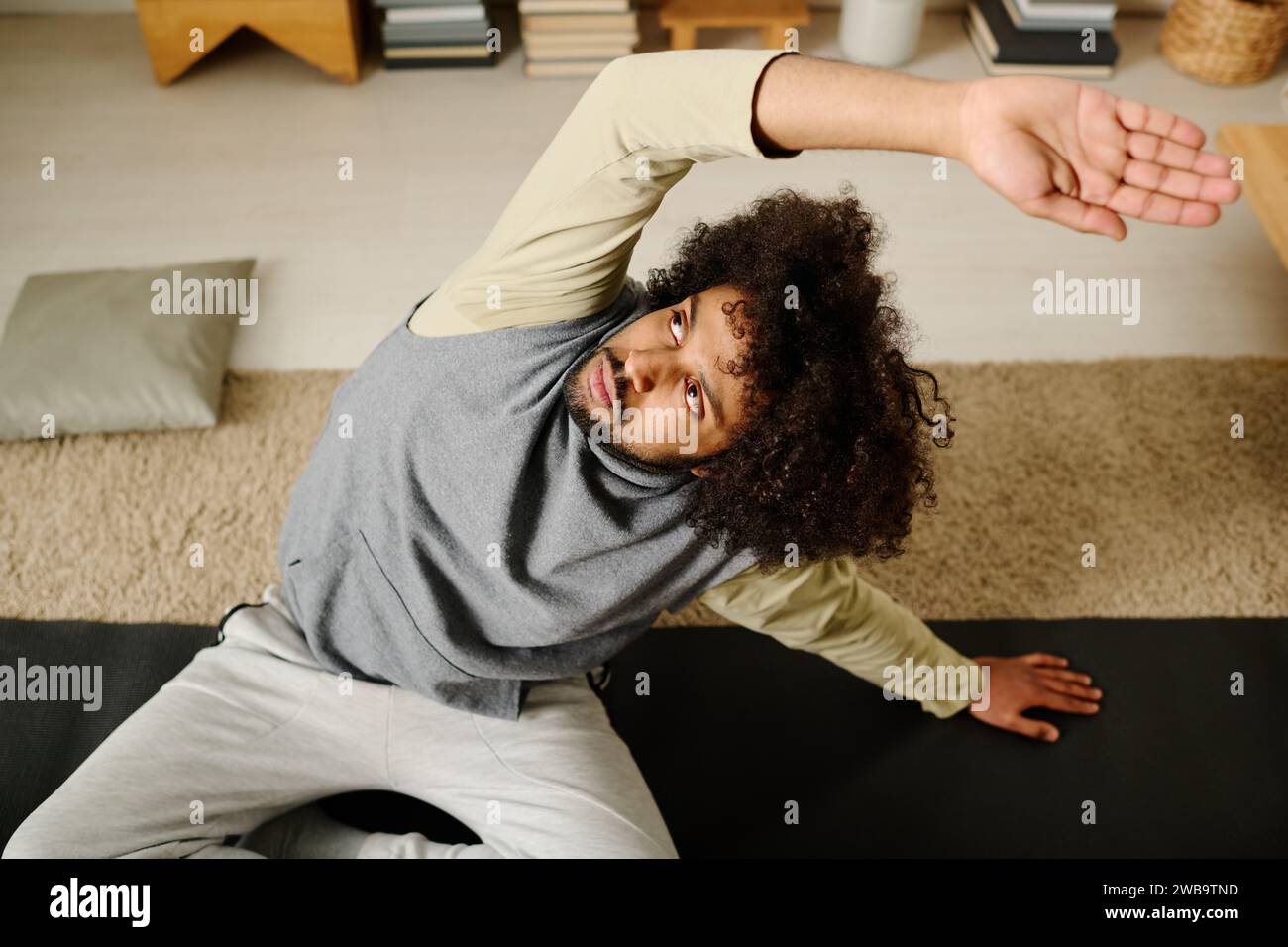High angle of young multiethnic man in activewear looking upwards at ...