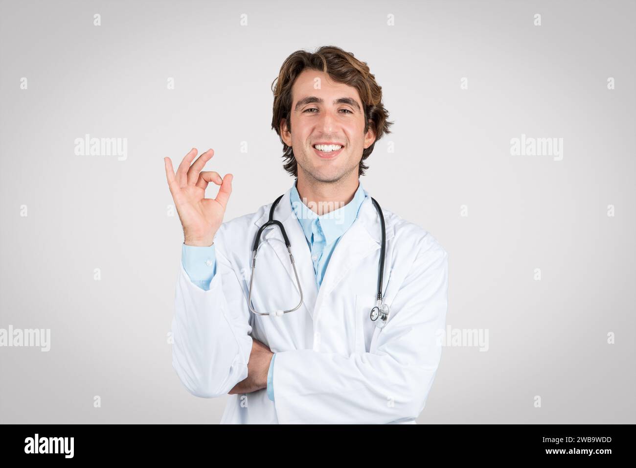 Doctor man giving 'okay' sign, symbolizing good health Stock Photo - Alamy