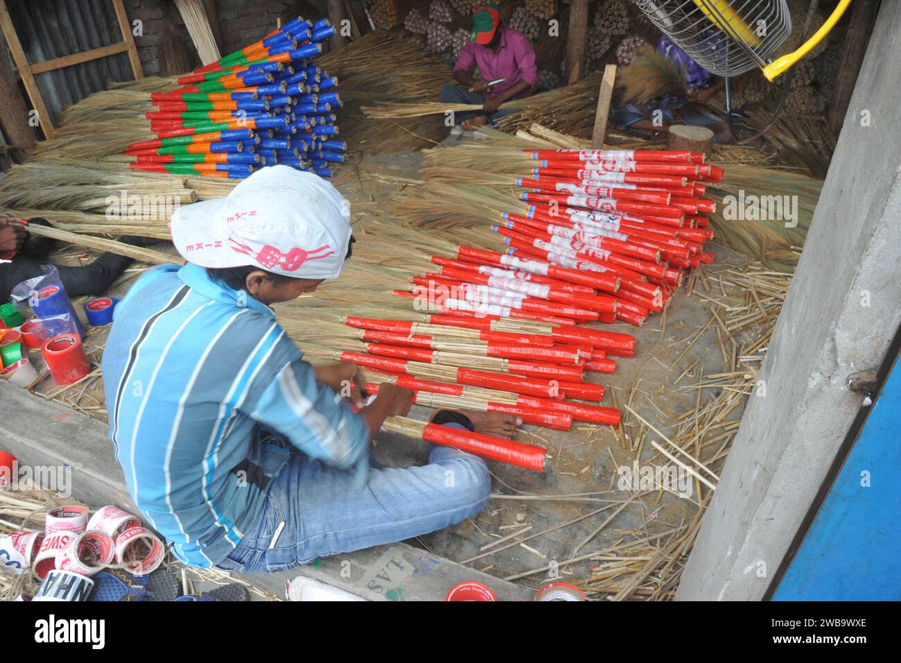 A worker at the local factory makes broom to sell Stock Photo - Alamy