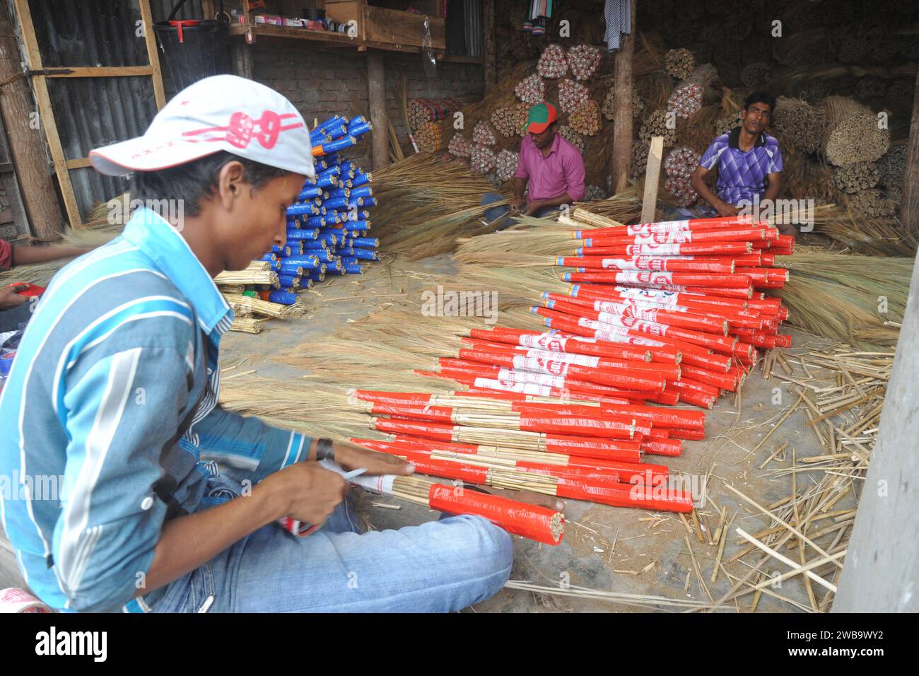 A worker at the local factory makes broom to sell Stock Photo - Alamy