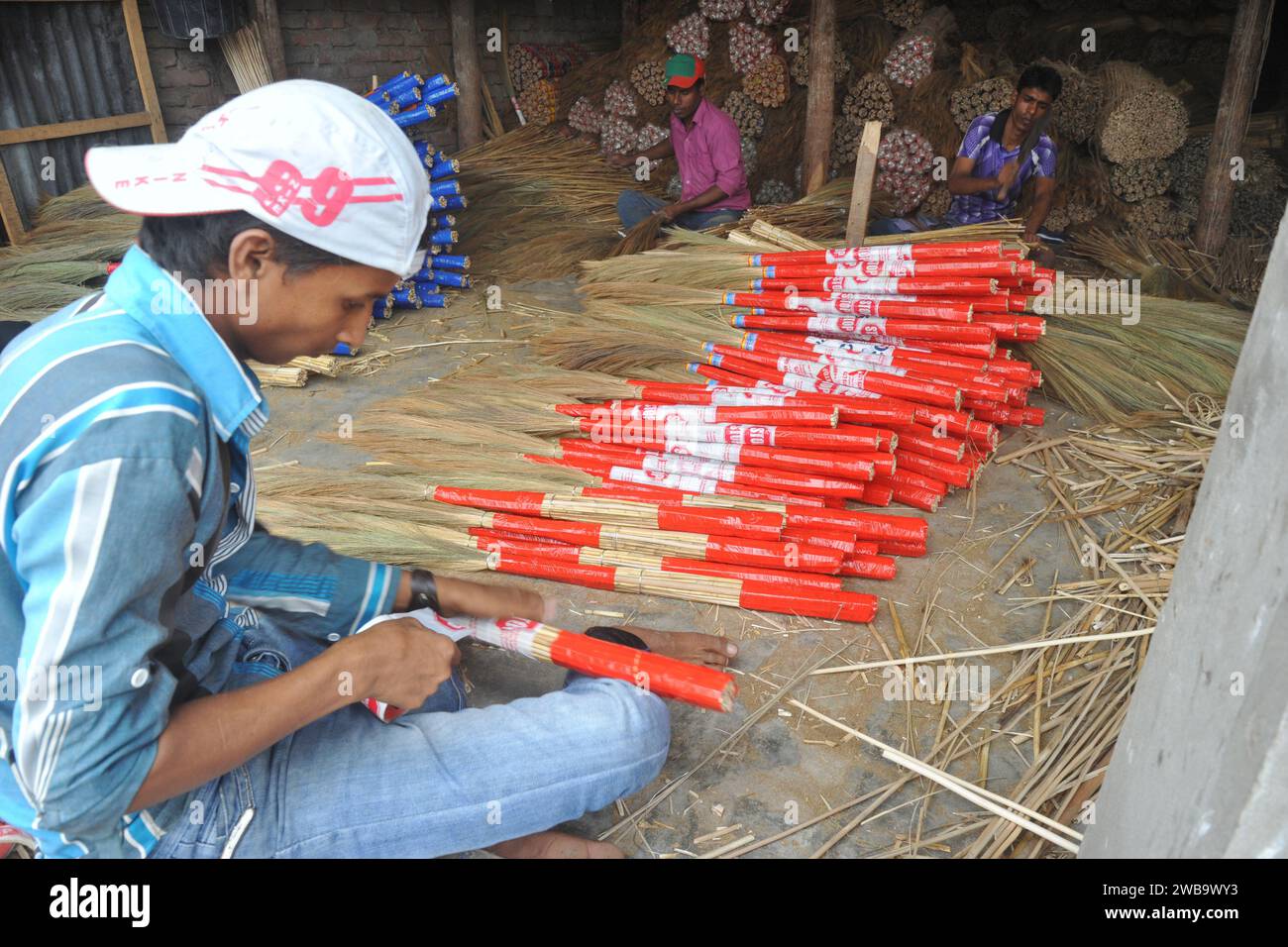 A worker at the local factory makes broom to sell Stock Photo - Alamy