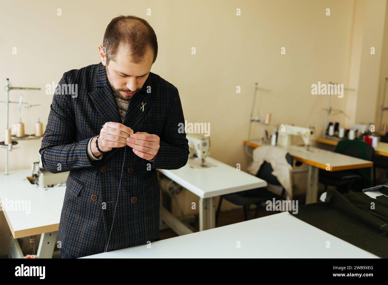 Tailor working at studio cutting fabric, detail of hand with scissors ...