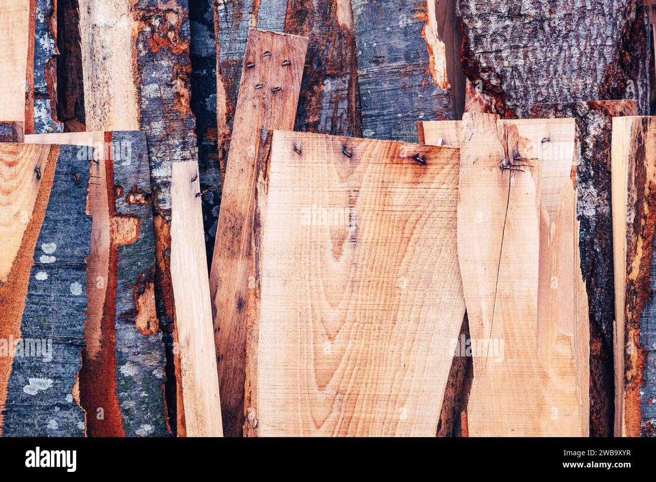 Firewood stack, wood remains from parquet preparation as background ...
