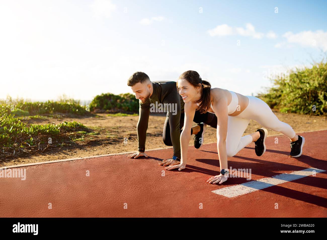 Couple in ready position for a race on track Stock Photo - Alamy