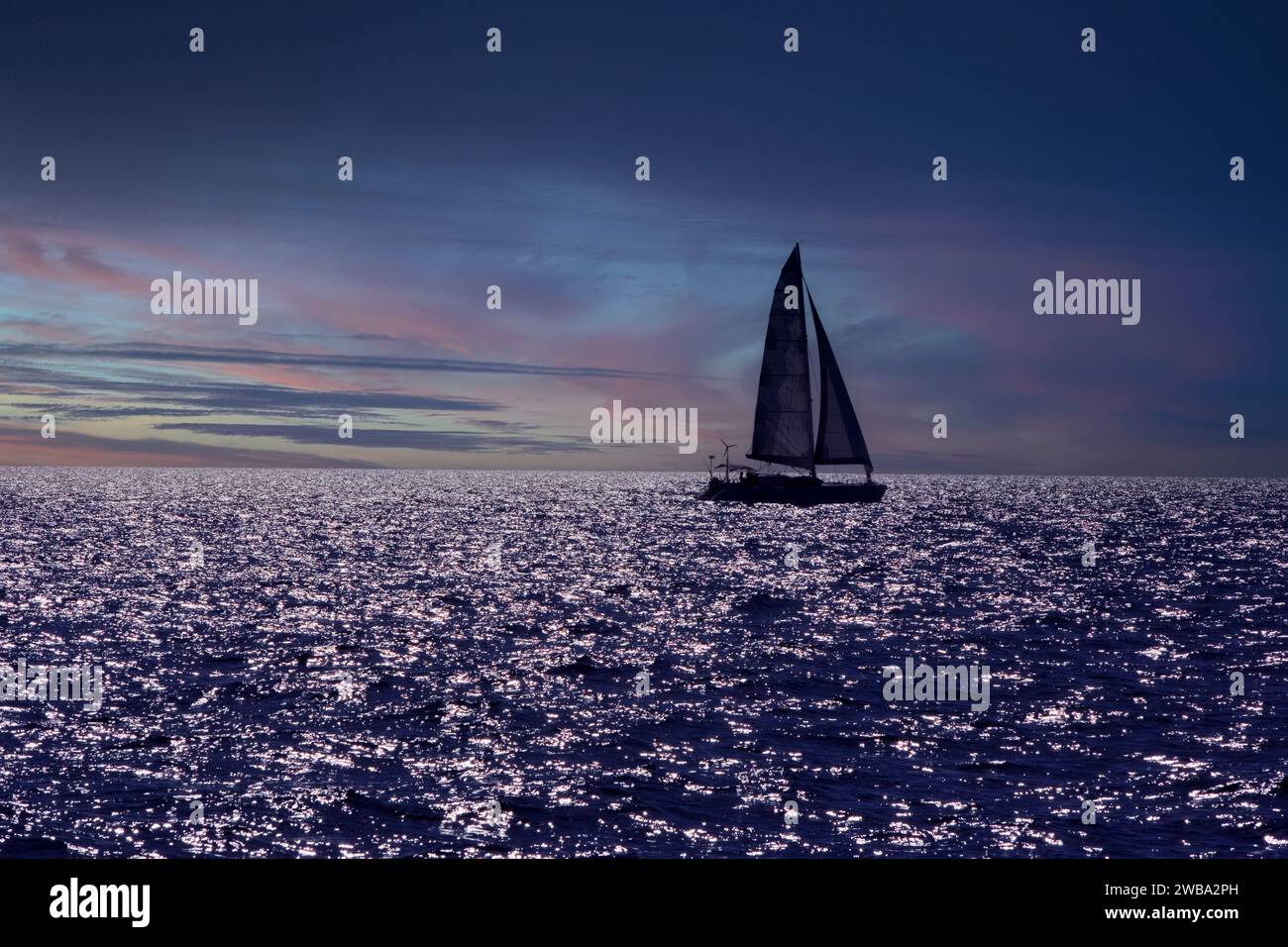 Single catamaran cruising the Bahamas at dusk Stock Photo - Alamy