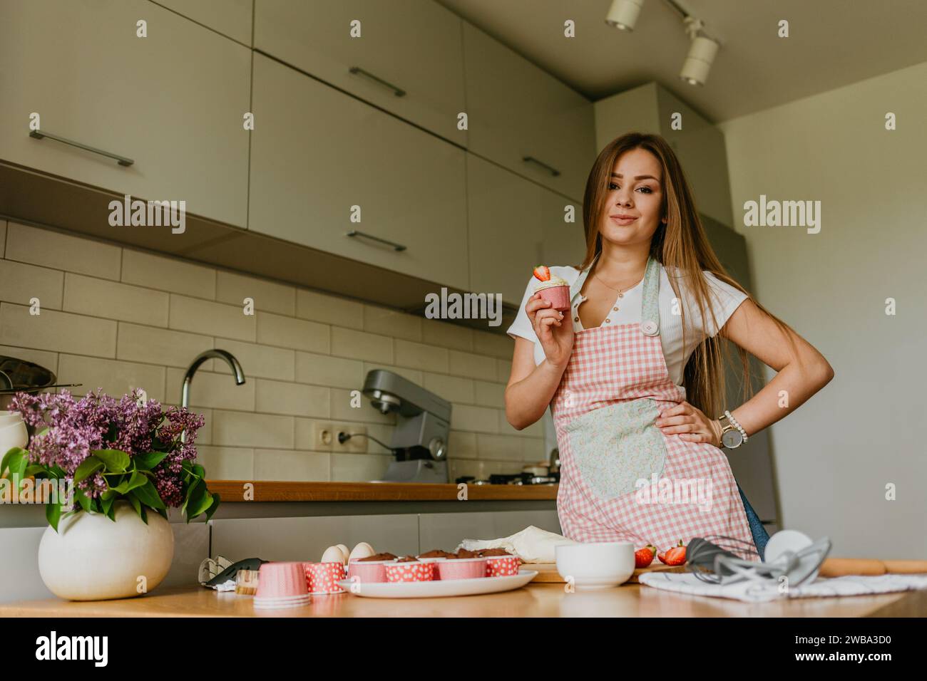 The action of making red velvet cupcakes. Woman hand piping cream ...