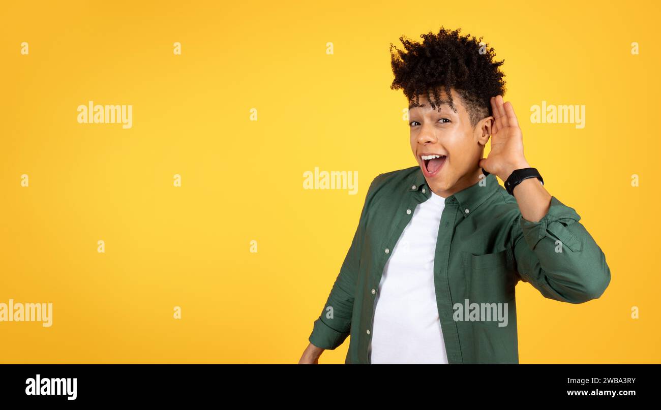 Curious young black guy holding hand next to ear, eavesdropping Stock ...