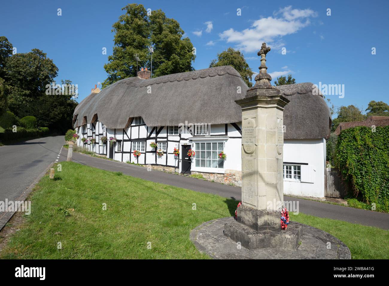 Thatched cottages and war memorial on the village green, Wherwell, Test ...