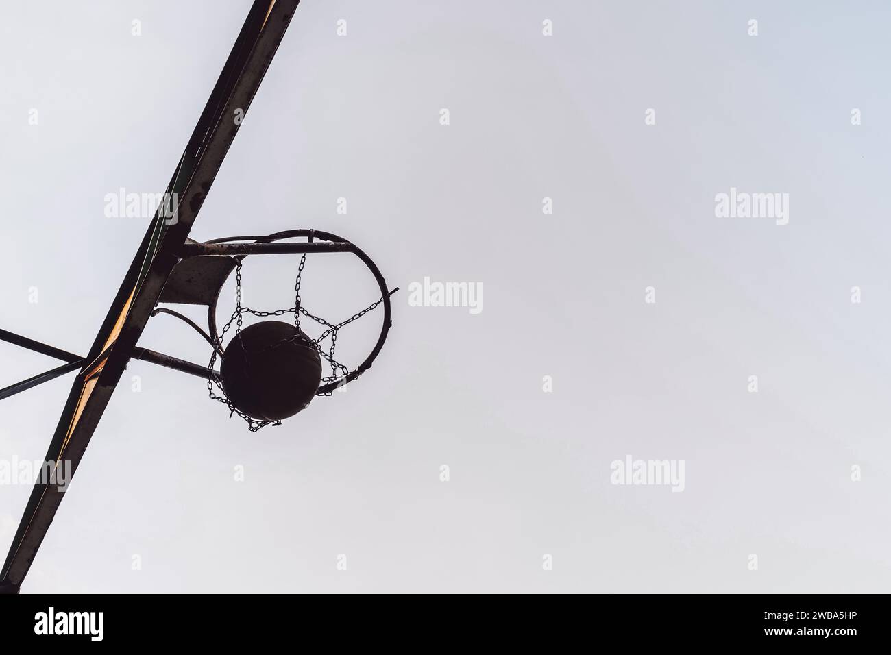 Street basketball ball falling into the hoop. Side view Stock Photo - Alamy