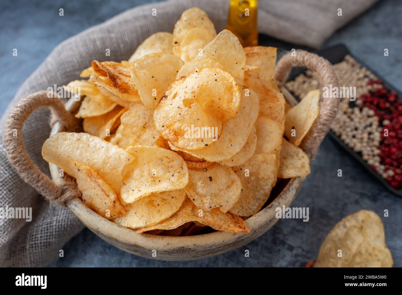 Savory chips in a handmade kraft bowl on a gray background. Potato ...