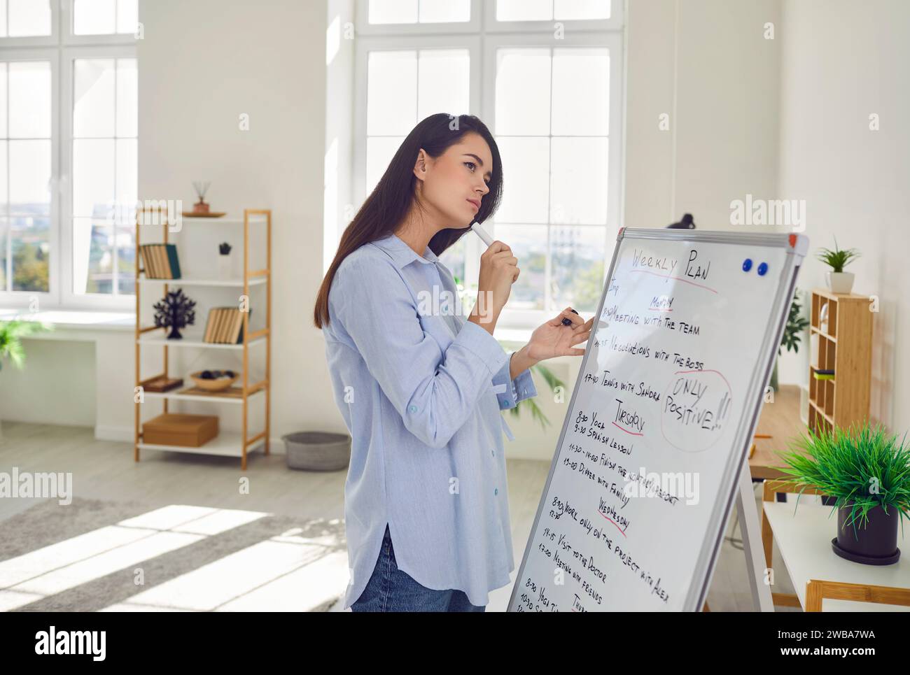 Woman Strategizing Weekly Schedule on Whiteboard Stock Photo - Alamy
