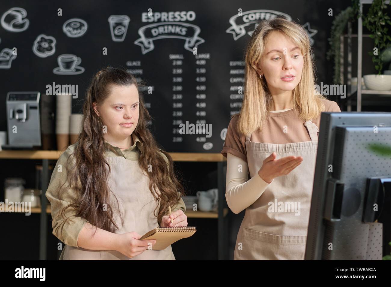 Young woman with disability holding notepad and looking at computer ...