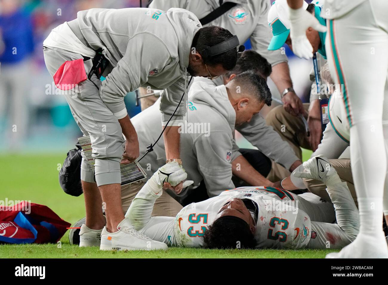Miami Dolphins head coach Mike McDaniel, left, holds the hand of ...