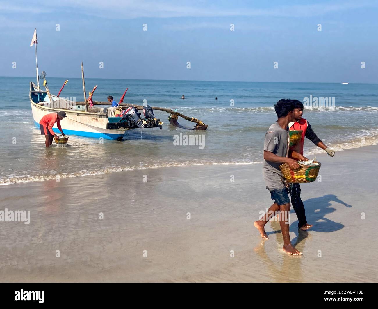 Fishermen on the beach at Benaulim in Goa, India, pull their nets ...