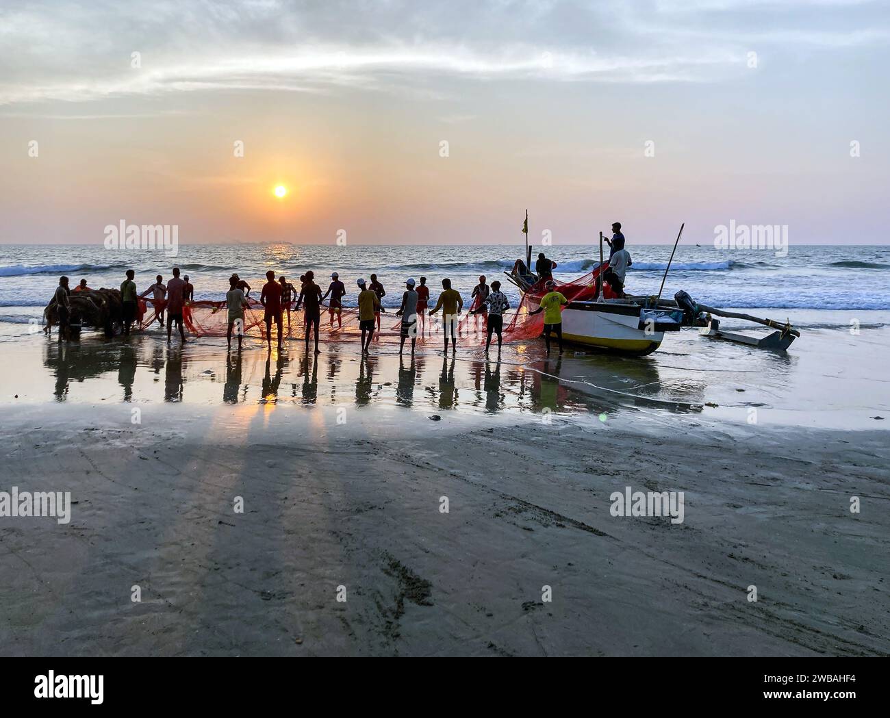 Fishermen on the beach at Benaulim in Goa, India, pull their nets ...