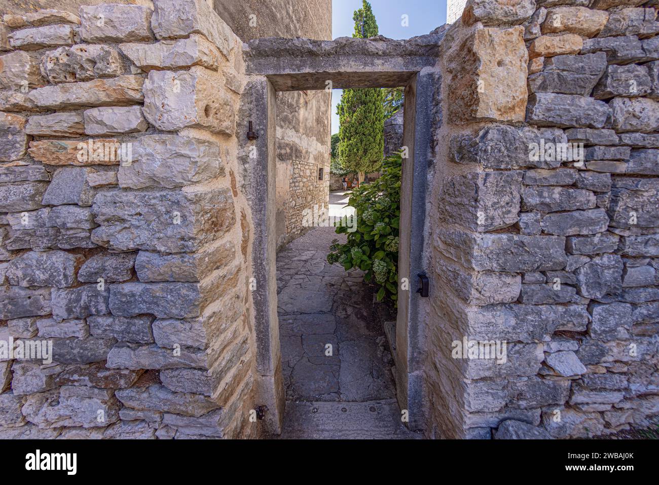 View through an old stone door frame without a door into a backyard of ...