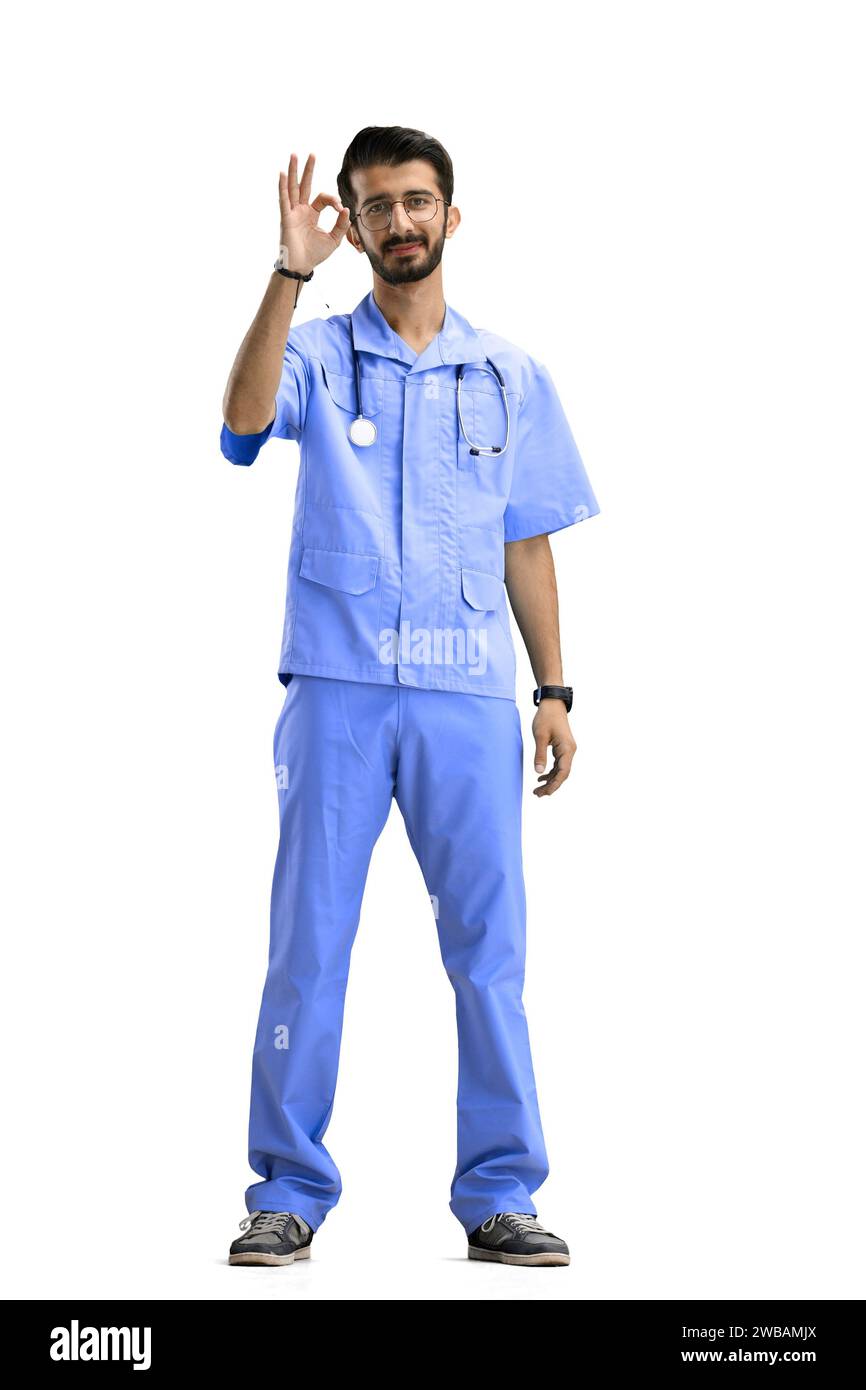 A male doctor, on a white background, in full height, shows the ok sign ...