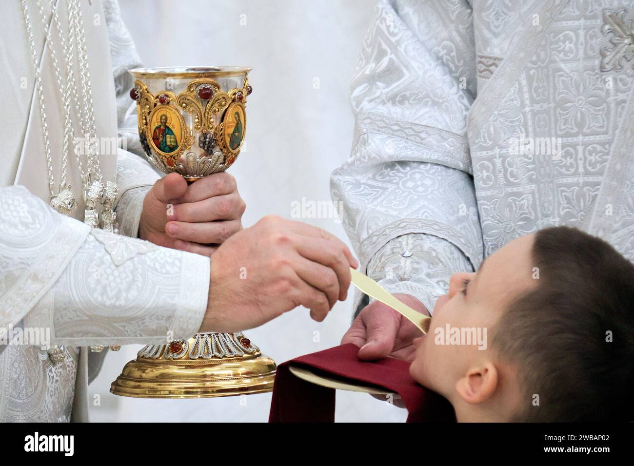 KYIV, UKRAINE - JANUARY 6, 2024 - A boy receives the Holy Communion ...