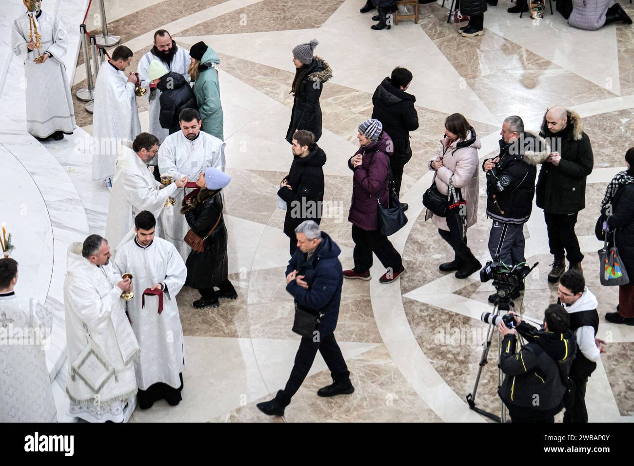 KYIV, UKRAINE - JANUARY 6, 2024 - Devotees stand in the lines to get ...