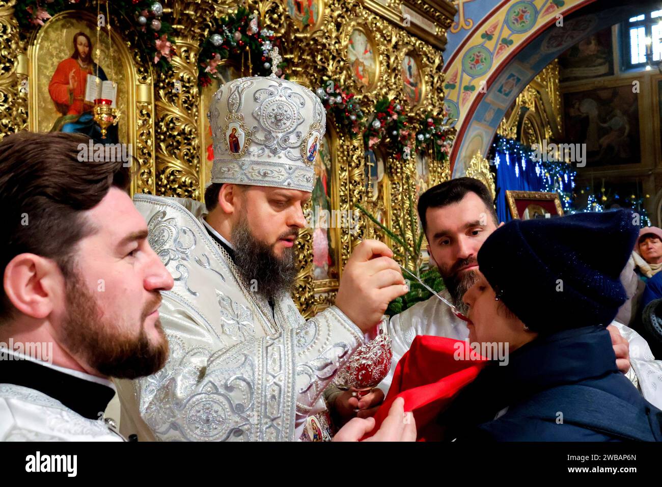 KYIV, UKRAINE - JANUARY 6, 2024 - A priest shares the Holy Communion ...