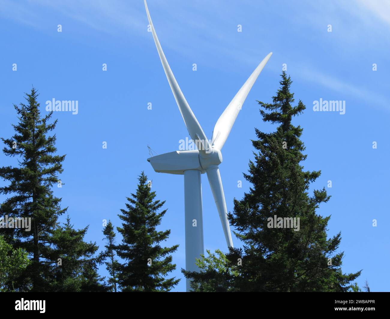 A high-angle view of a wind turbine in a rural landscape, with a few ...
