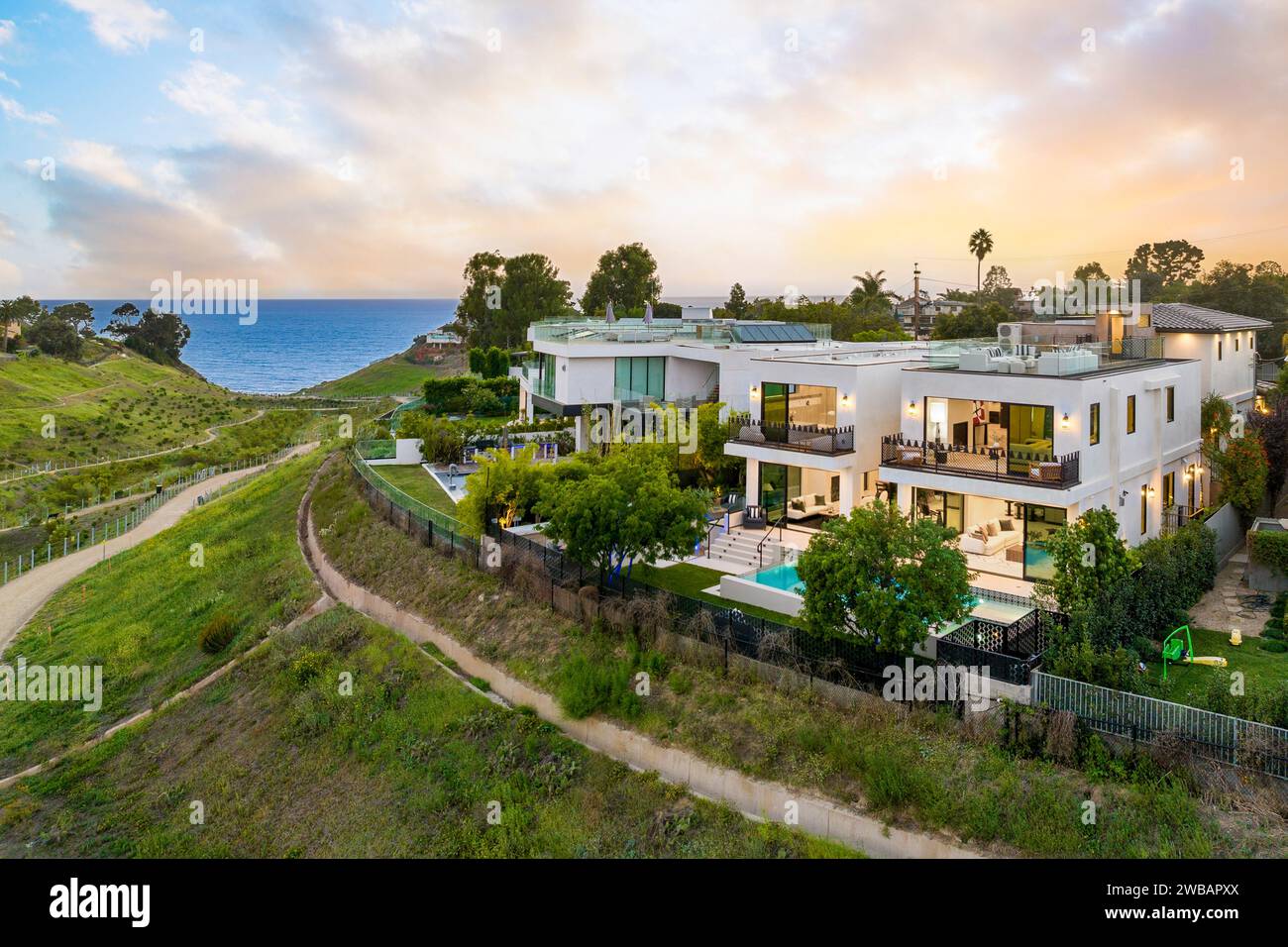 Aerial view of beachfront property, illuminated by the setting sun ...