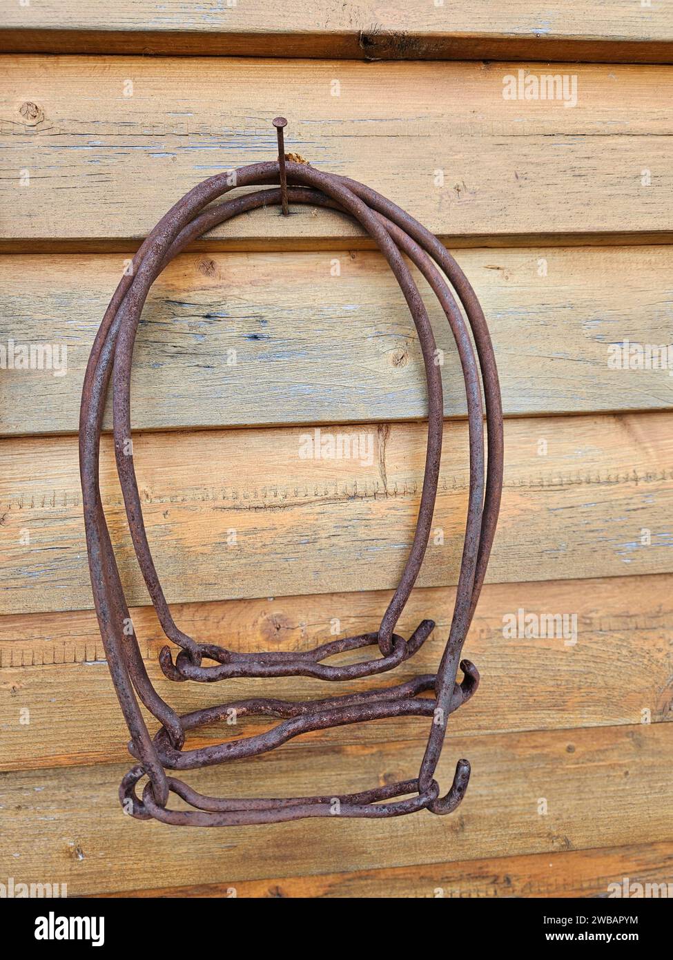 An aged wooden wall with two oxidized metal frames resting atop it ...