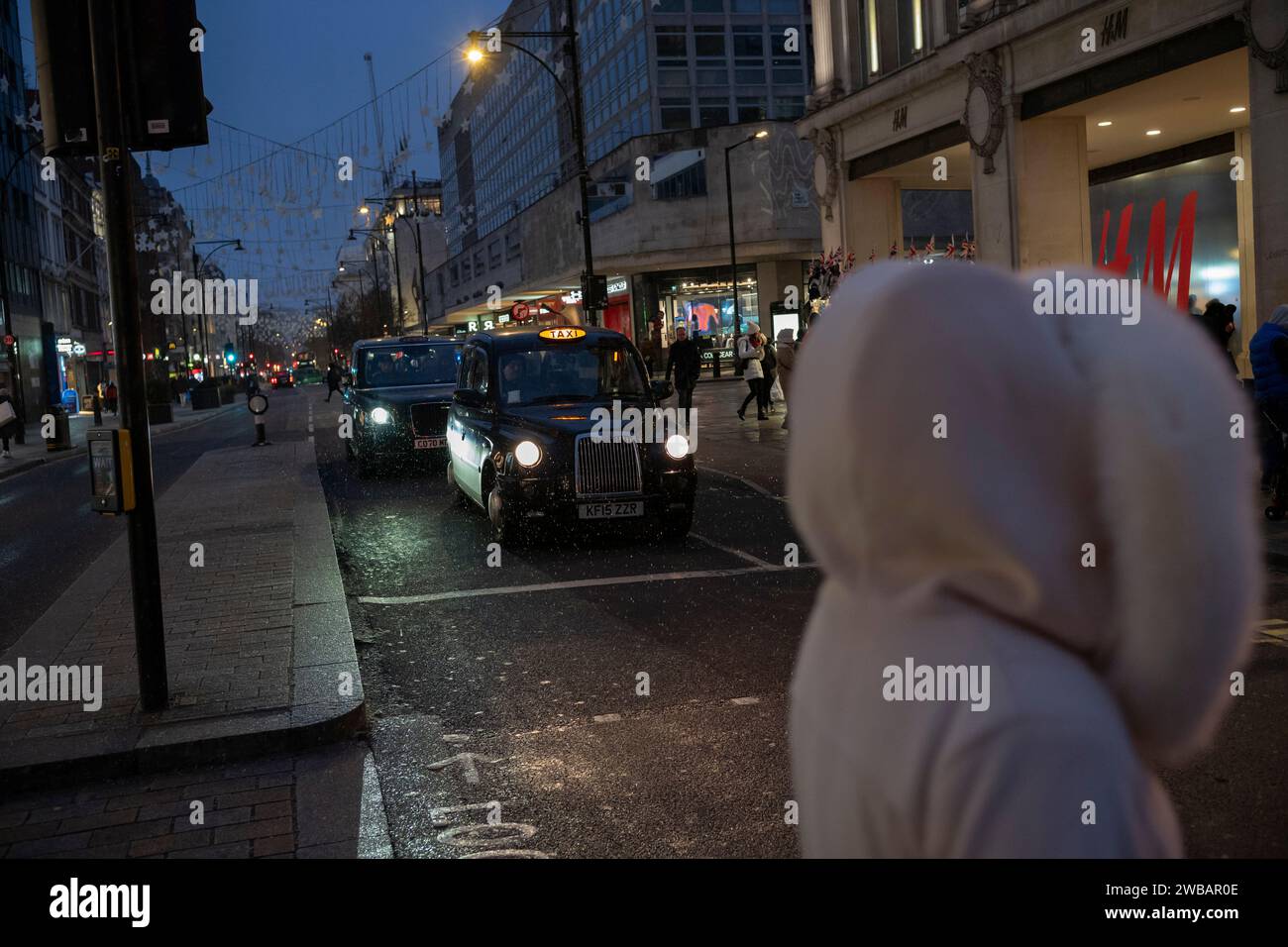 Shoppers brave the cold winter weather during freezing sleet and rain ...