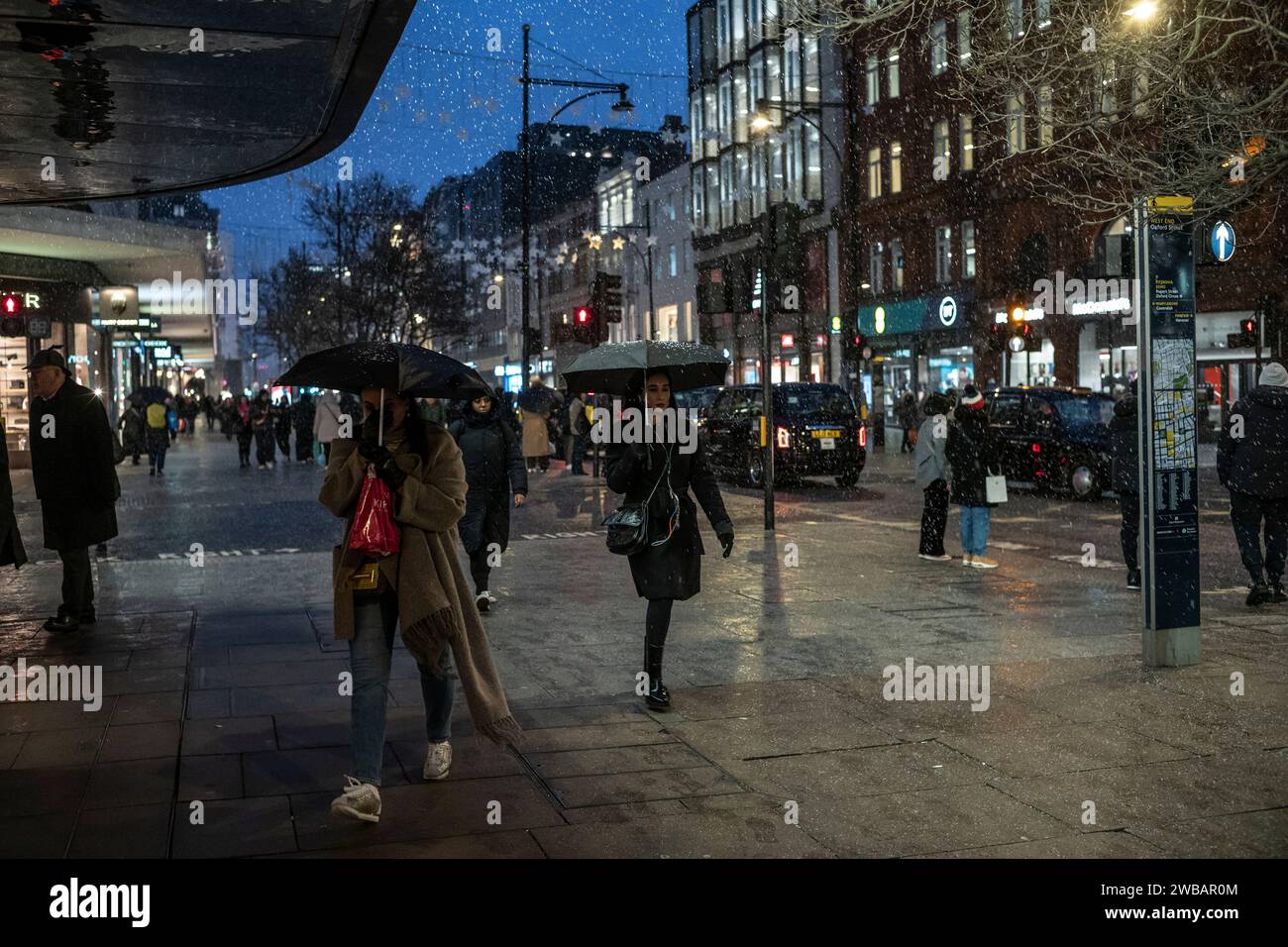 Shoppers brave the cold winter weather during freezing sleet and rain ...