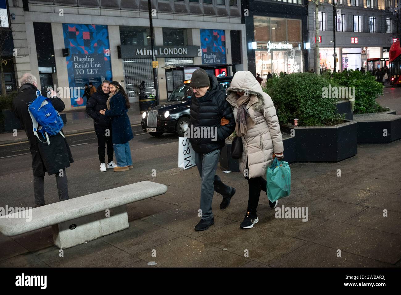 Shoppers brave the cold winter weather during freezing sleet and rain ...