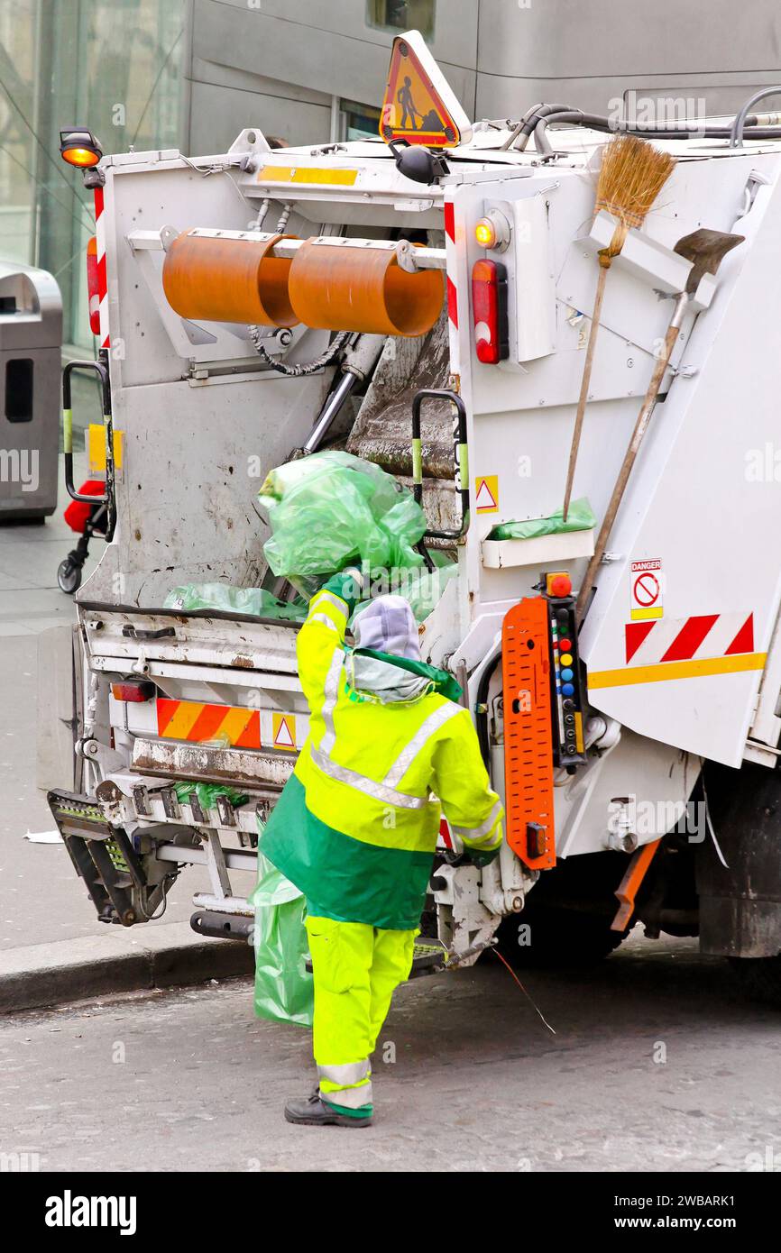 Garbage worker with bag at dump truck Stock Photo - Alamy