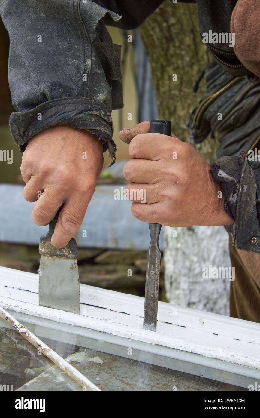 old wrinkled hands work a chisel on a tree Stock Photo - Alamy