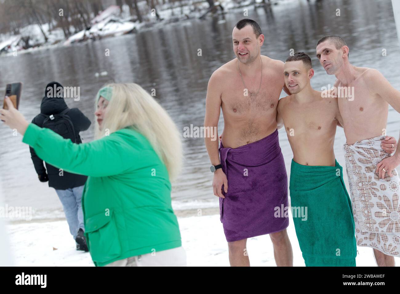 KYIV, UKRAINE - JANUARY 6, 2024 - Men pose for a photo after bathing in ...